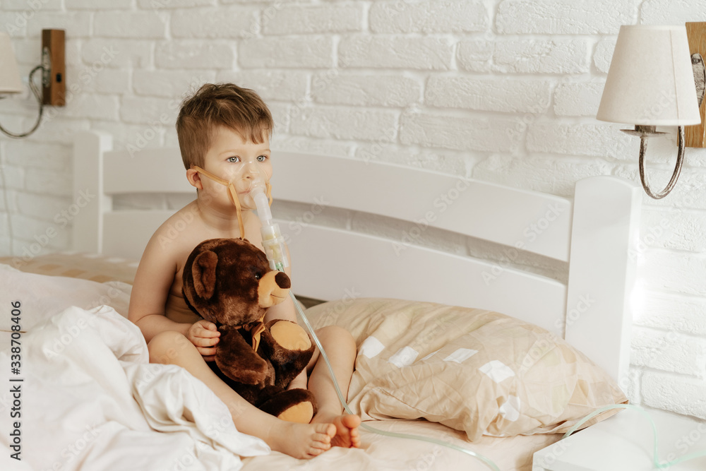 Little Boy in Nebulizer Face Mask Hold Teddy Bear Sitting on Bed. Sad ...
