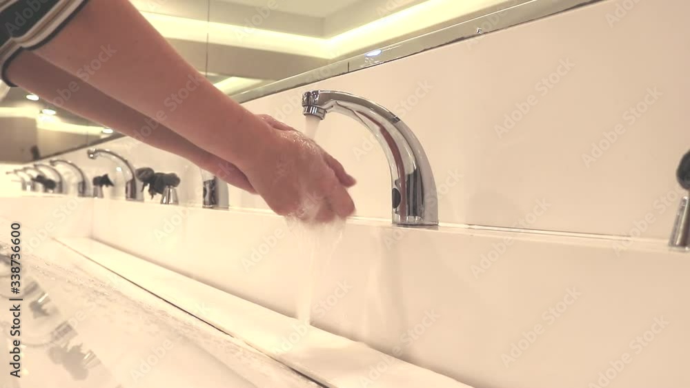 Contactless hand washing at the mall. Hand washing in a public toilet ...