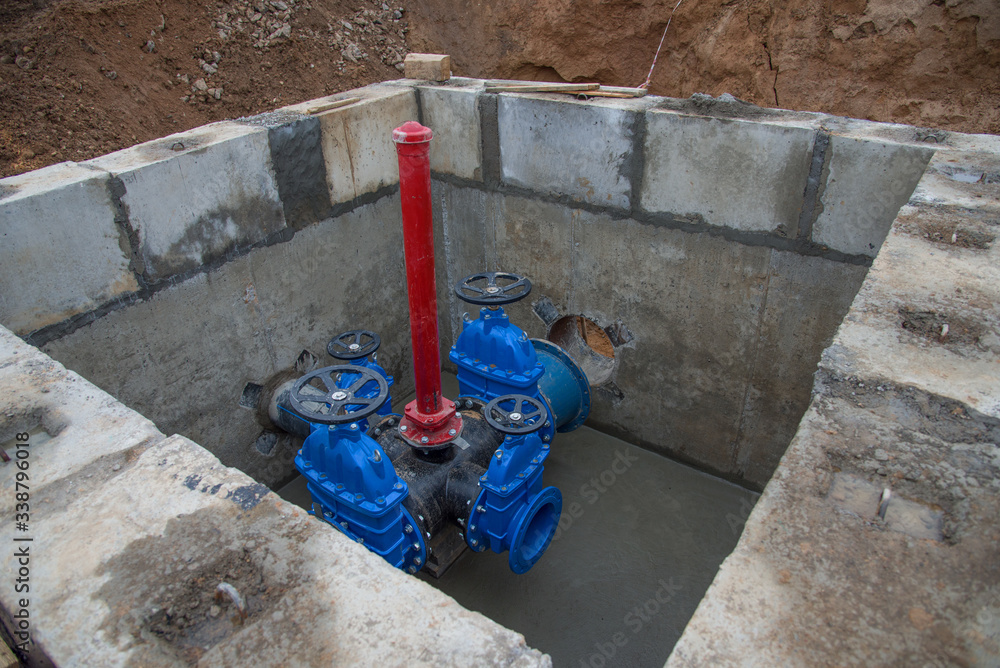 Gate valves in valve pit of the underground piping networks. Laying ...