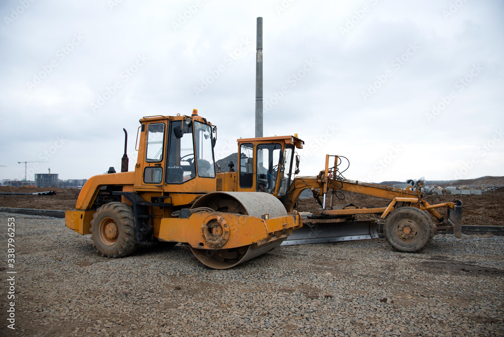 Motor Grader and Soil Compactor at a construction site level the ground ...