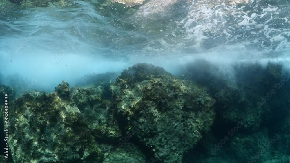 choppy water wavy sea underwater wave hit on rocks and makes foam on ...