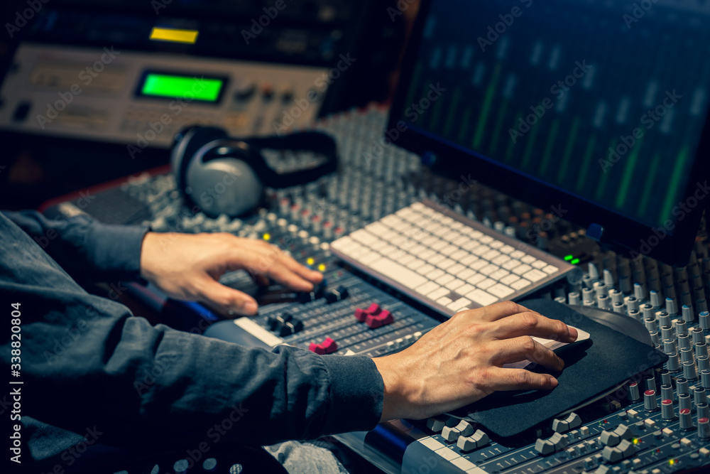 sound engineer hands working on audio mixing console, computer and ...