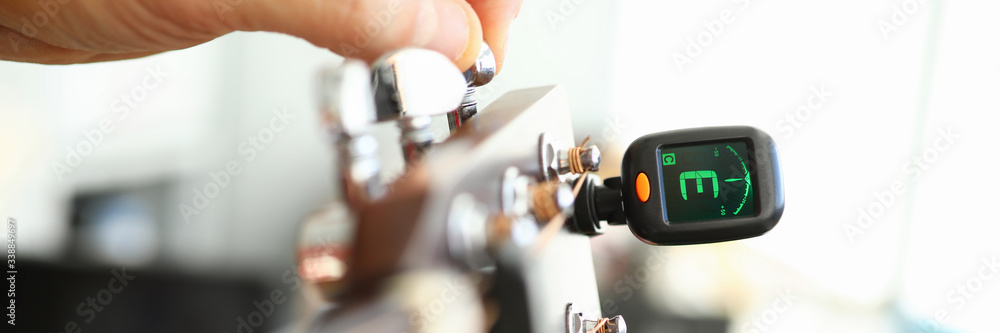 Tuner is installed on guitar neck for tuning notes Stock Photo | Adobe ...