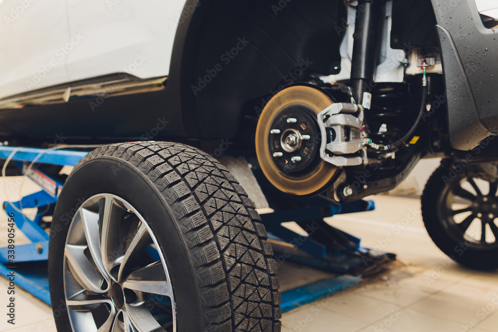modern car service. back view of car in room service. Wheel replacement ...