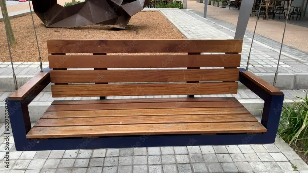 Suspended swinging outdoor metal and wooden bench Stock Video | Adobe Stock