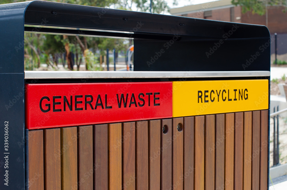 An outdoor public garbage bin with dual compartments for general and ...