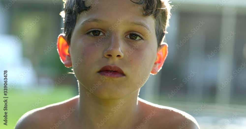 Boy scratching ear casually outside. Portrait of kid scratches body ...