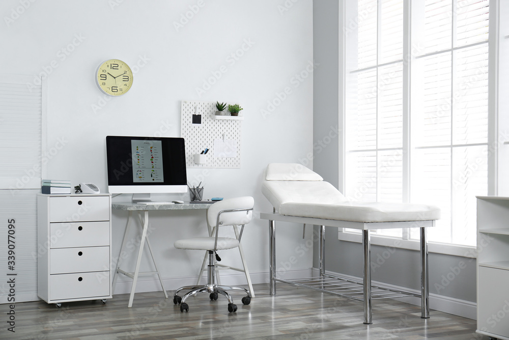 Modern medical office interior with computer and examination table ...