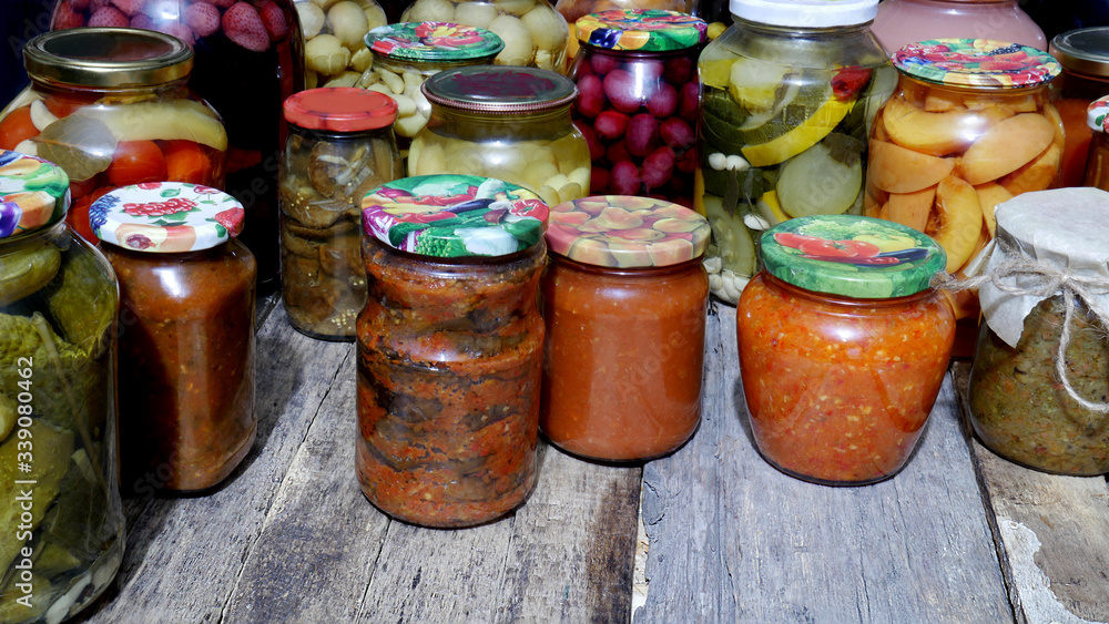 The canned products - vegetables and fruits in glass jars with on an ...