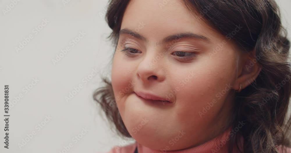 Portrait of adorable teen girl having down syndrome. Close up view of ...