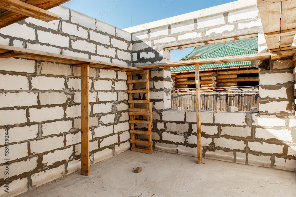 Building site of a house under construction. Unfinished house walls made from white aerated ...