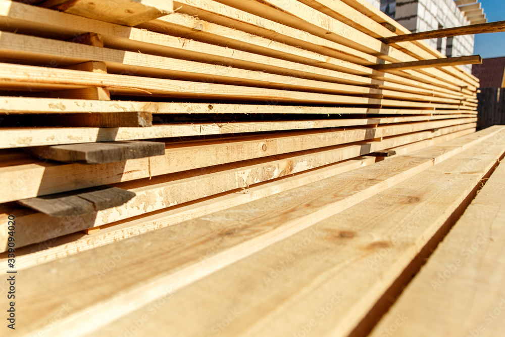 Stack of new wooden studs at the lumber yard. Timber on the ...