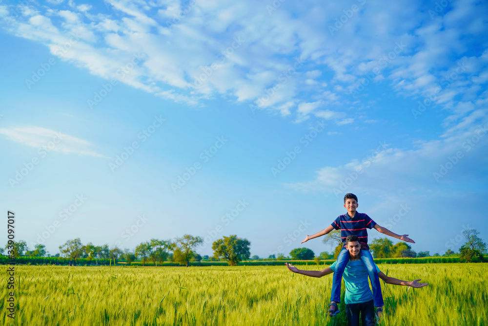 Brother Piggyback His Little Brother In Wheat Field Rural India Stock