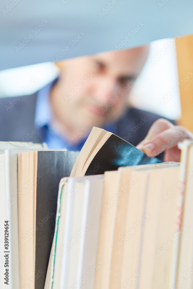 Man as a reader is looking for a book in the bookshop Stock Photo ...
