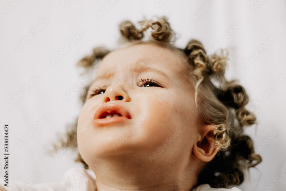 Foto de Little curly girl is crying very emotionally, face with tears ...