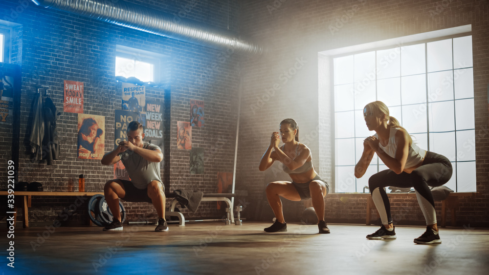 Strong Masculine Man and Two Fit Athletic Women are Doing Squat ...