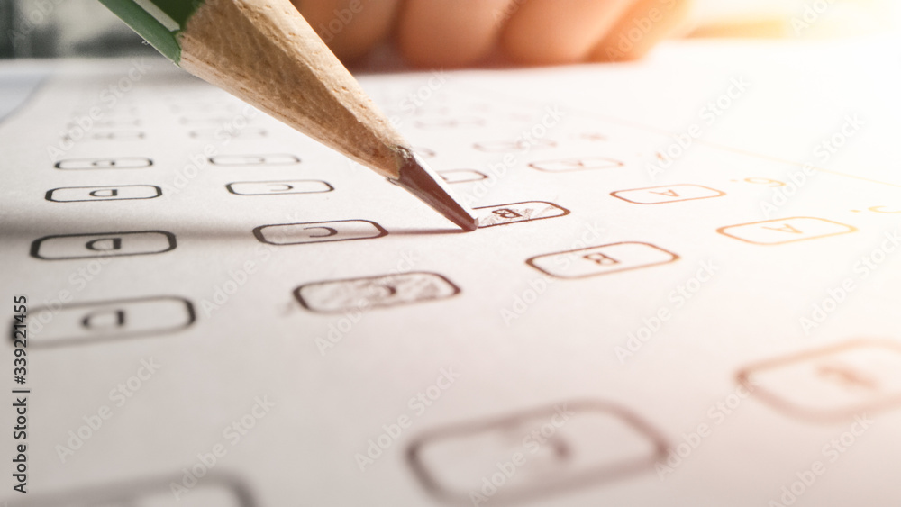 Foto de On Exam Test Person Colors Right Answers with a Pencil. Filling ...