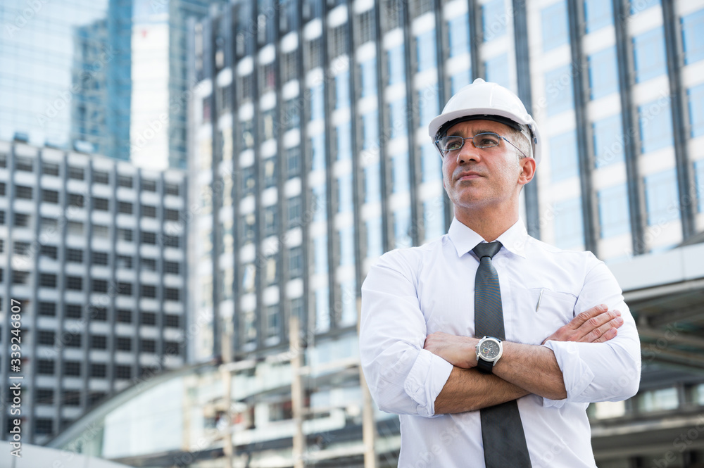 Portrait of senior civil engineer doing thinking,smiling,arm cross on ...