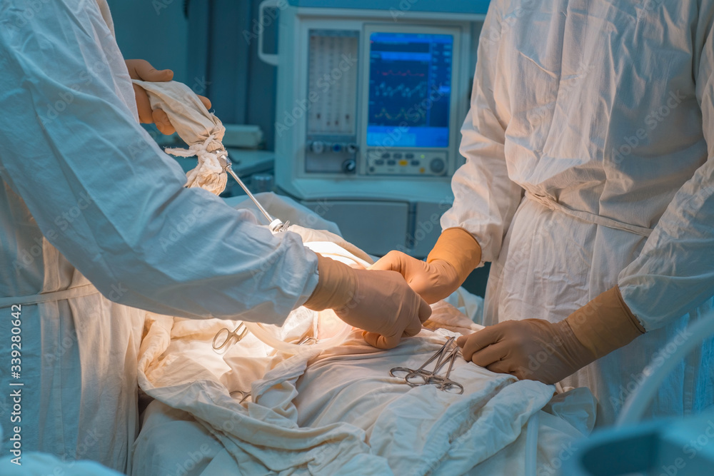 close-up hands of pediatric surgeons perform surgery using laparoscopic ...