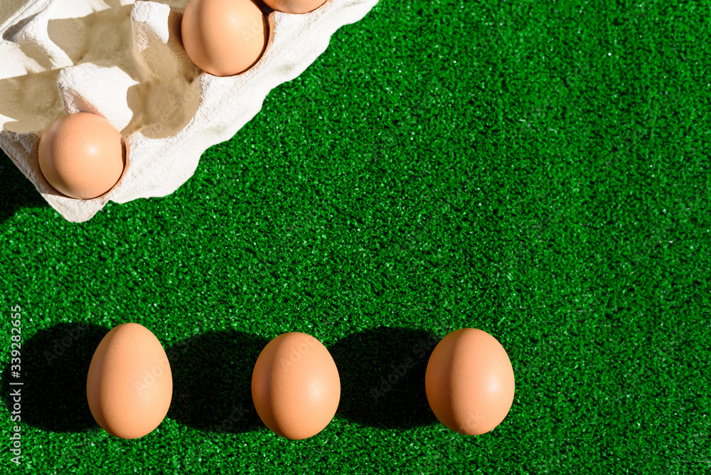 Top view of chicken eggs ans paper egg box. Green background and ...