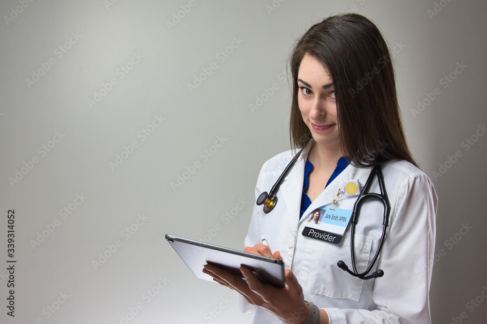 Nurse practitioner making notes on tablet for patient charting. Female ...