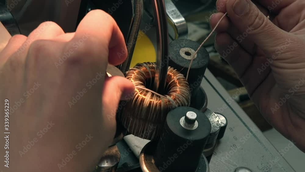 Transformer engine production modern plant Worker hands wind the cooper ...