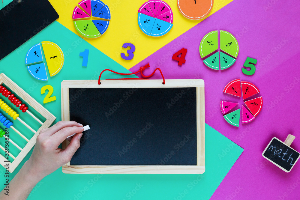 Kid writes by left hand on school board. Colorful math fractions and ...