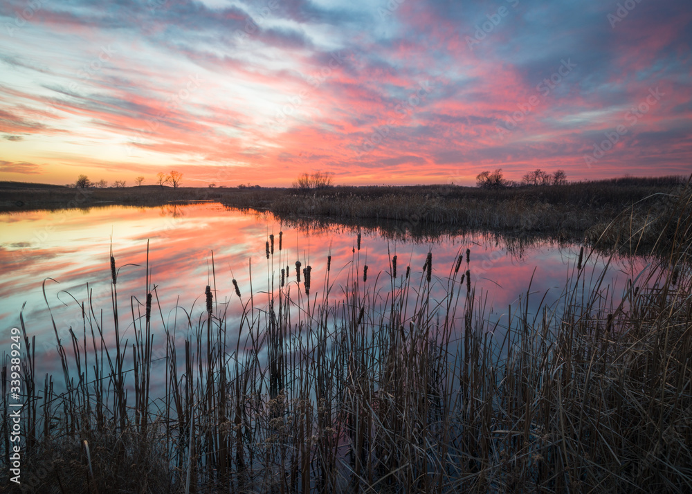 A dramatic sunset sky marks the end of the day at a wetland nature ...