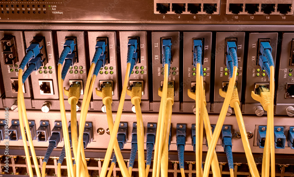 Fiber Optic cables connected to an optic ports and Network cables ...