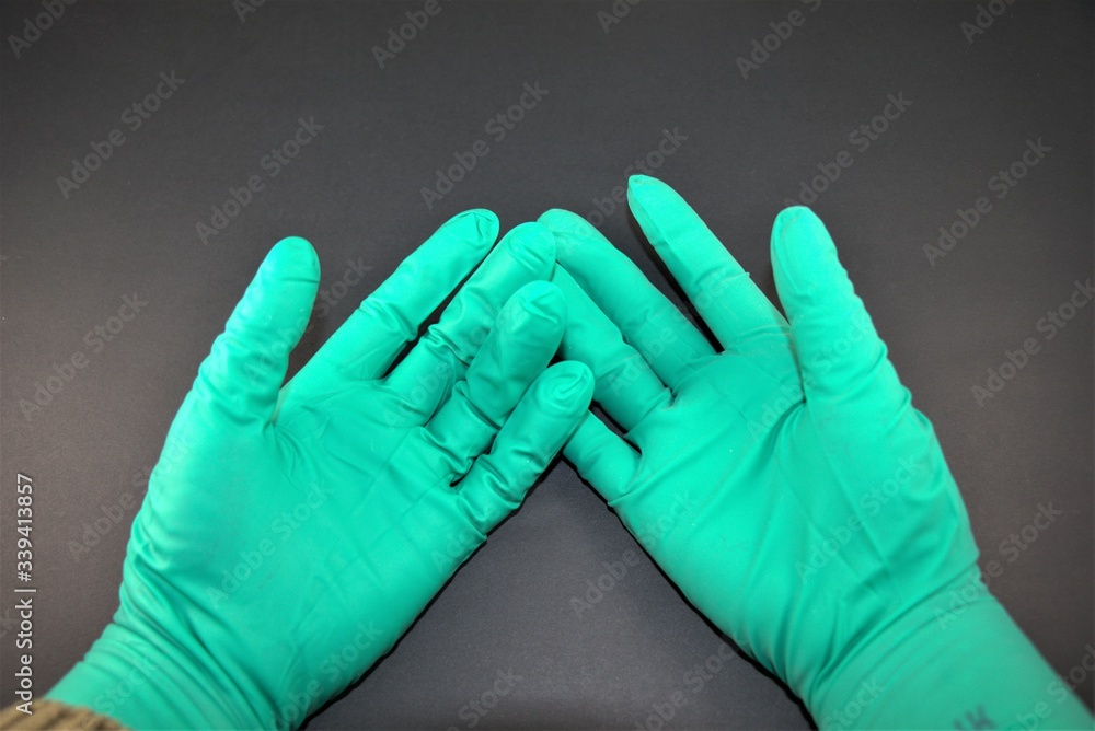 Human hands wearing sterile surgical gloves isolated on black ...