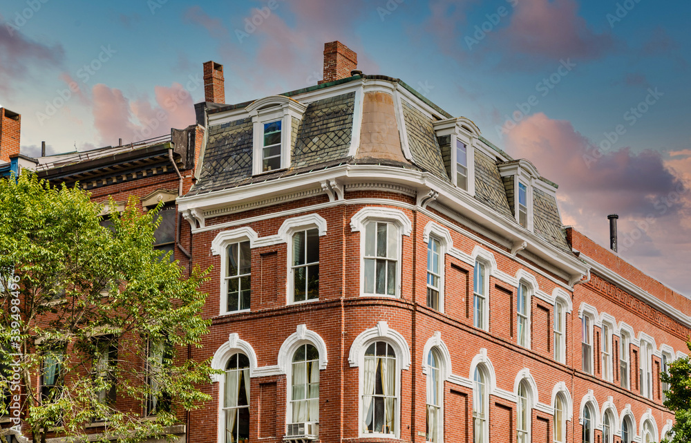 Old red brick building with arched windows and a mansard roof Stock ...