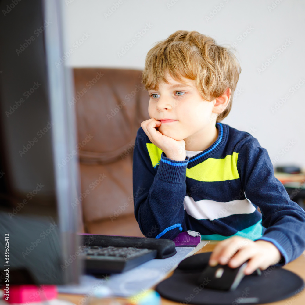 Little school kid boy making school homework on computer. Child ...