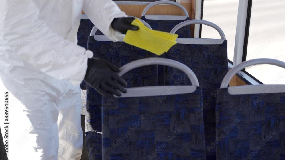 Hazmat team worker disinfects bus interior with antibacterial sanitizer ...