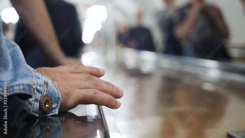 Man's hand with dark hair in Jean jacket nervously moving fingers ...