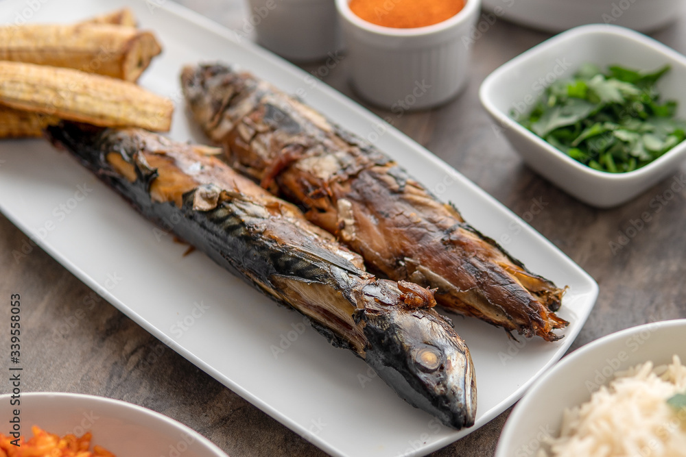 Nigerian fried food dish. Grilled fish with plantain. Nigerian cuisine ...