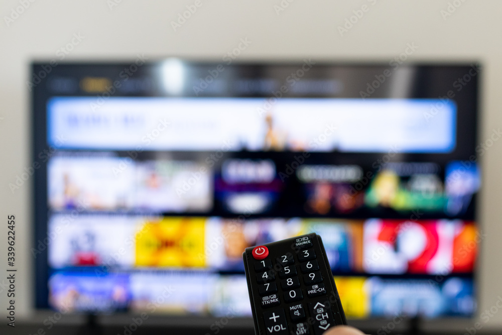 Tv remote controller in hand of customer looking for some content in ...