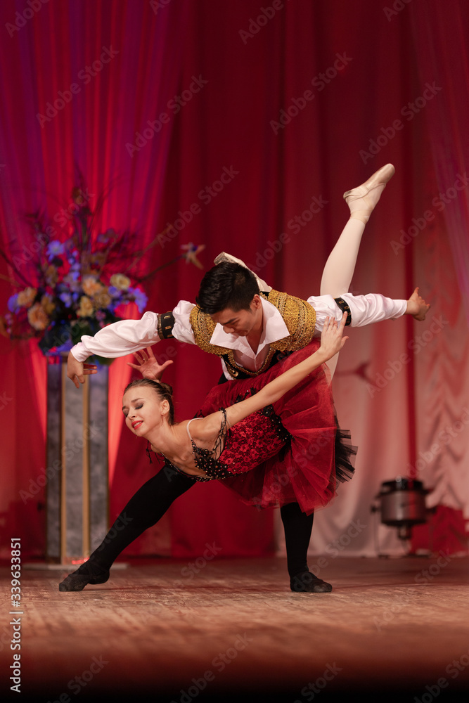 Duet young girl ballerina and a young man dancing ballet performance on ...
