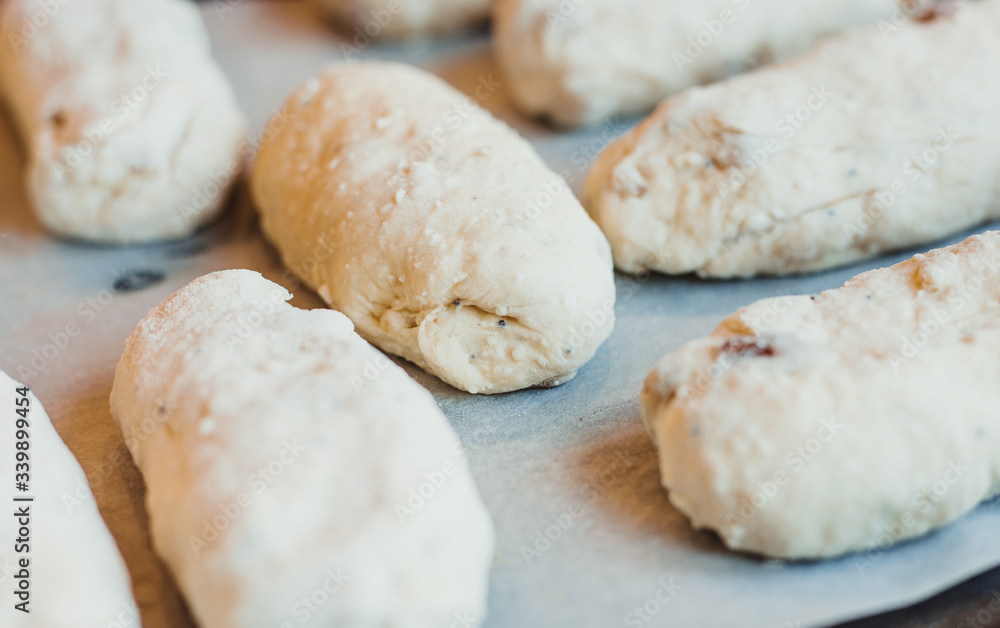 Raw curd buns with raisins lie on a baking sheet. Raw dough. Unbaked ...