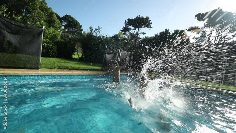 Children having fun in home backyard swimming pool. Kid jumping into ...