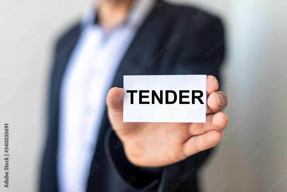 Sticker with text " Tender " on a white paper holding by a man in suit ...