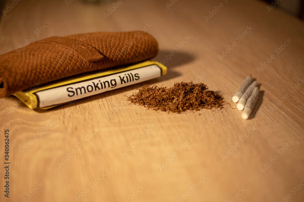 Rolling cigarette by using blended tobacco paper and filter on close up ...