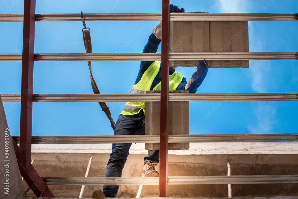 Workers installing roofs wearing safety clothing Construction of a ...