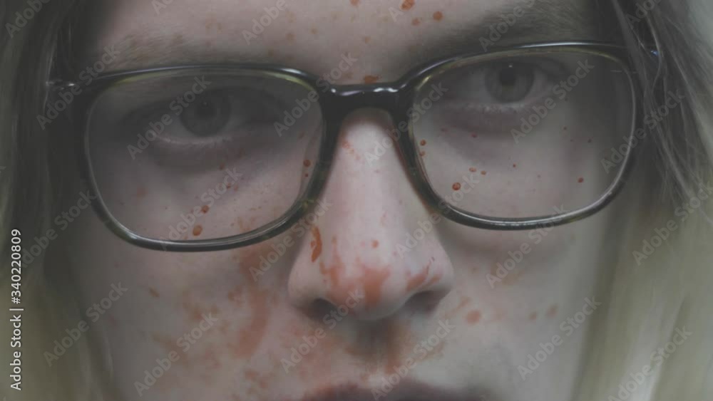 Killer in blood looks at camera. Stock. Young man with downcast eyes ...
