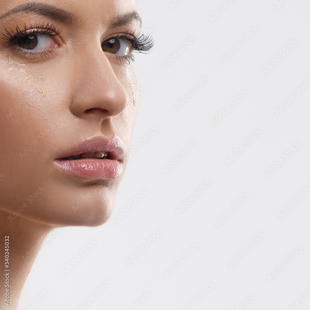 tear on the cheek of a beautiful young woman. Emotions and sadness ...