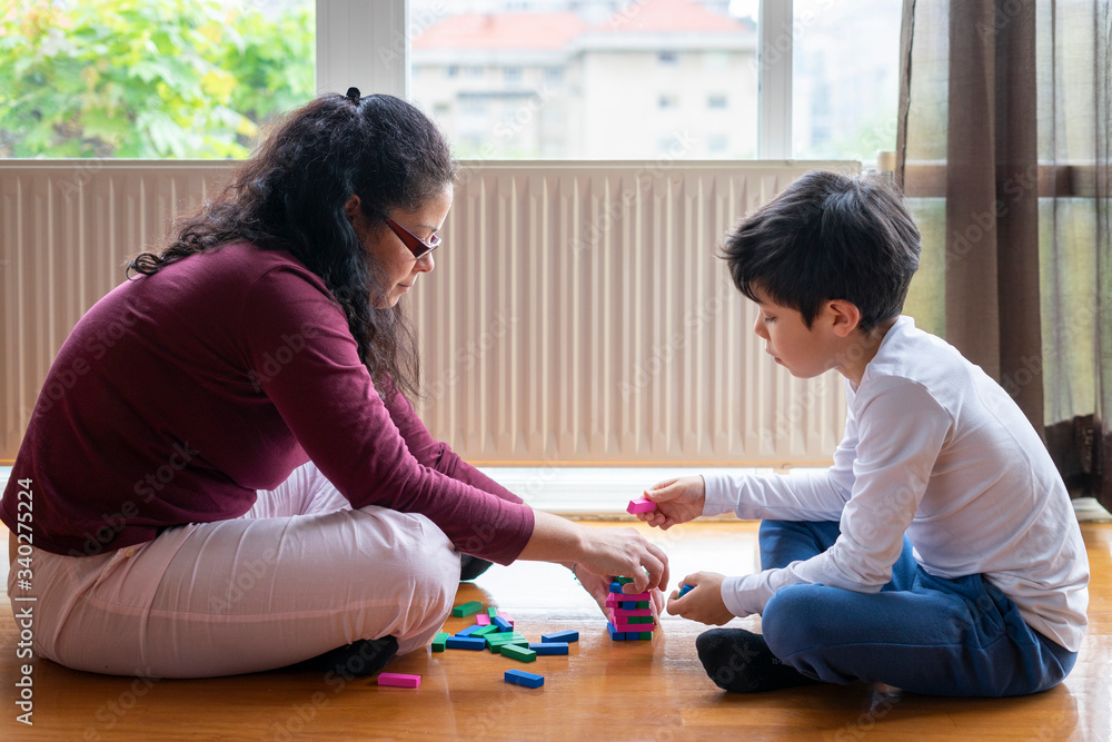 Mother and son playing colorful wooden blocks stack tower game for ...