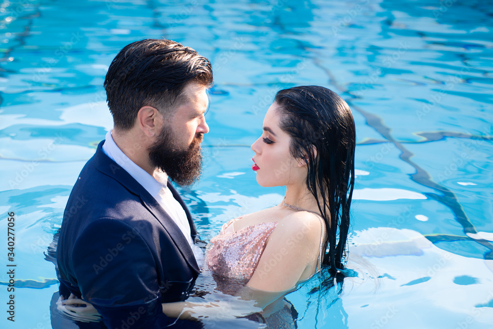 Couple in love with dress in swimming pool. Beautiful girl in a dress ...