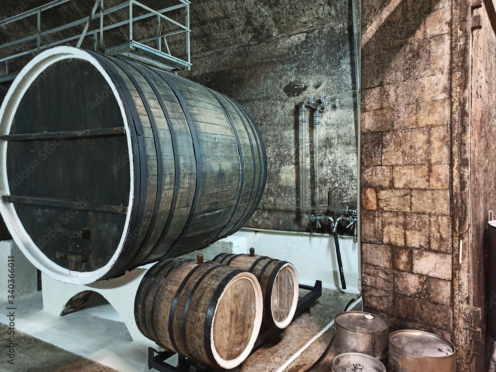 Wine barrels stacked in the old cellar of the winery.The concept of ...