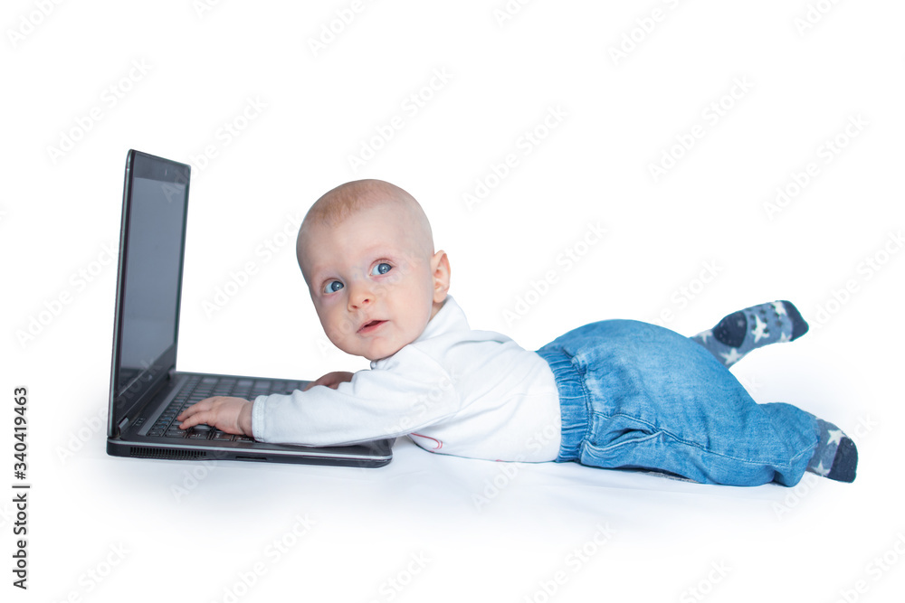 Baby boy tired, upset, sleeping on the black laptop with white screen ...