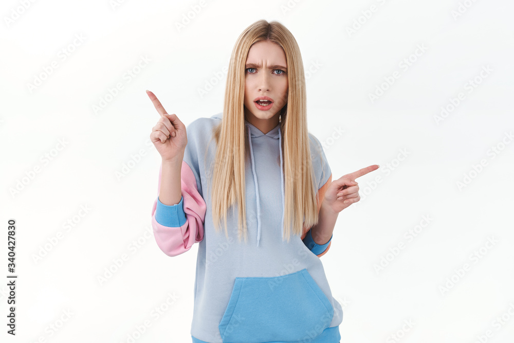 Confused young blonde girl with frowning face, asking question ...