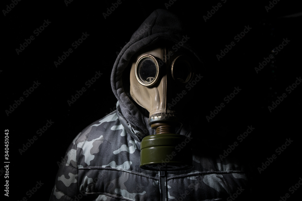 Gas mask with clouds of smoke on a dark background. Sign of radioactive ...